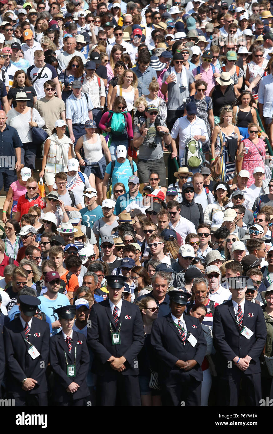 Spectators wait to be led into the grounds on day two of the Wimbledon ...