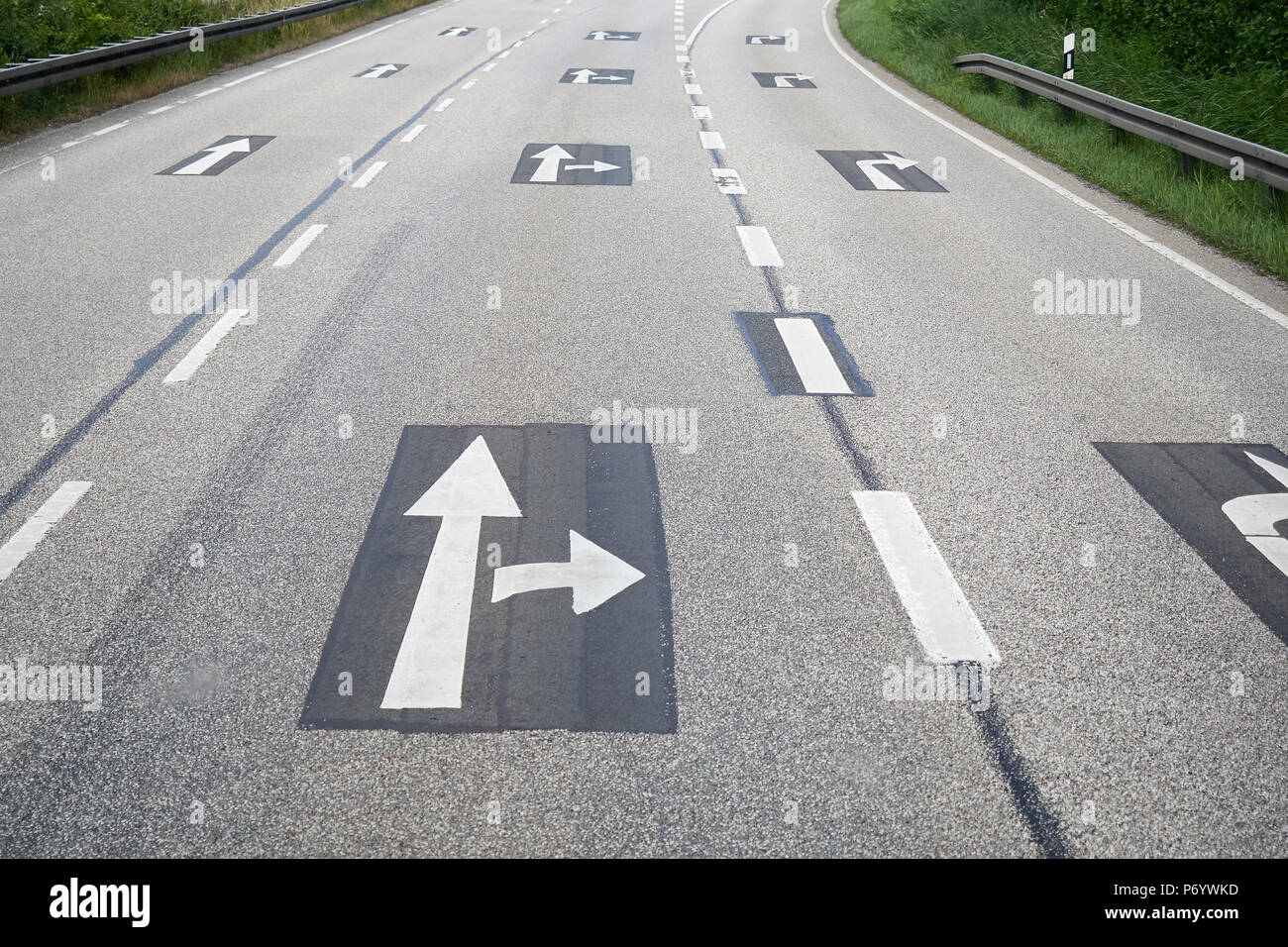 Directional arrows sign printed on asphalt in empty highway or freeway ...