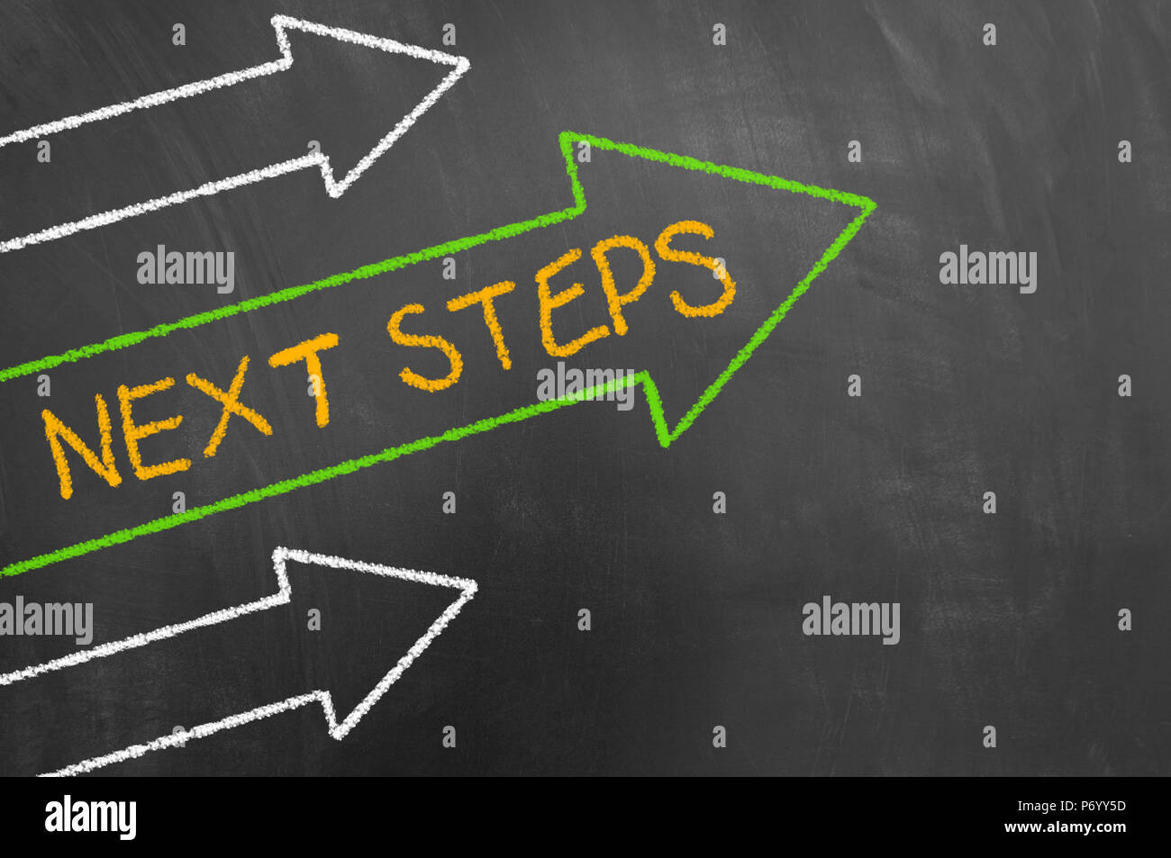 Next steps progress concept with chalk text and direction arrows on ...
