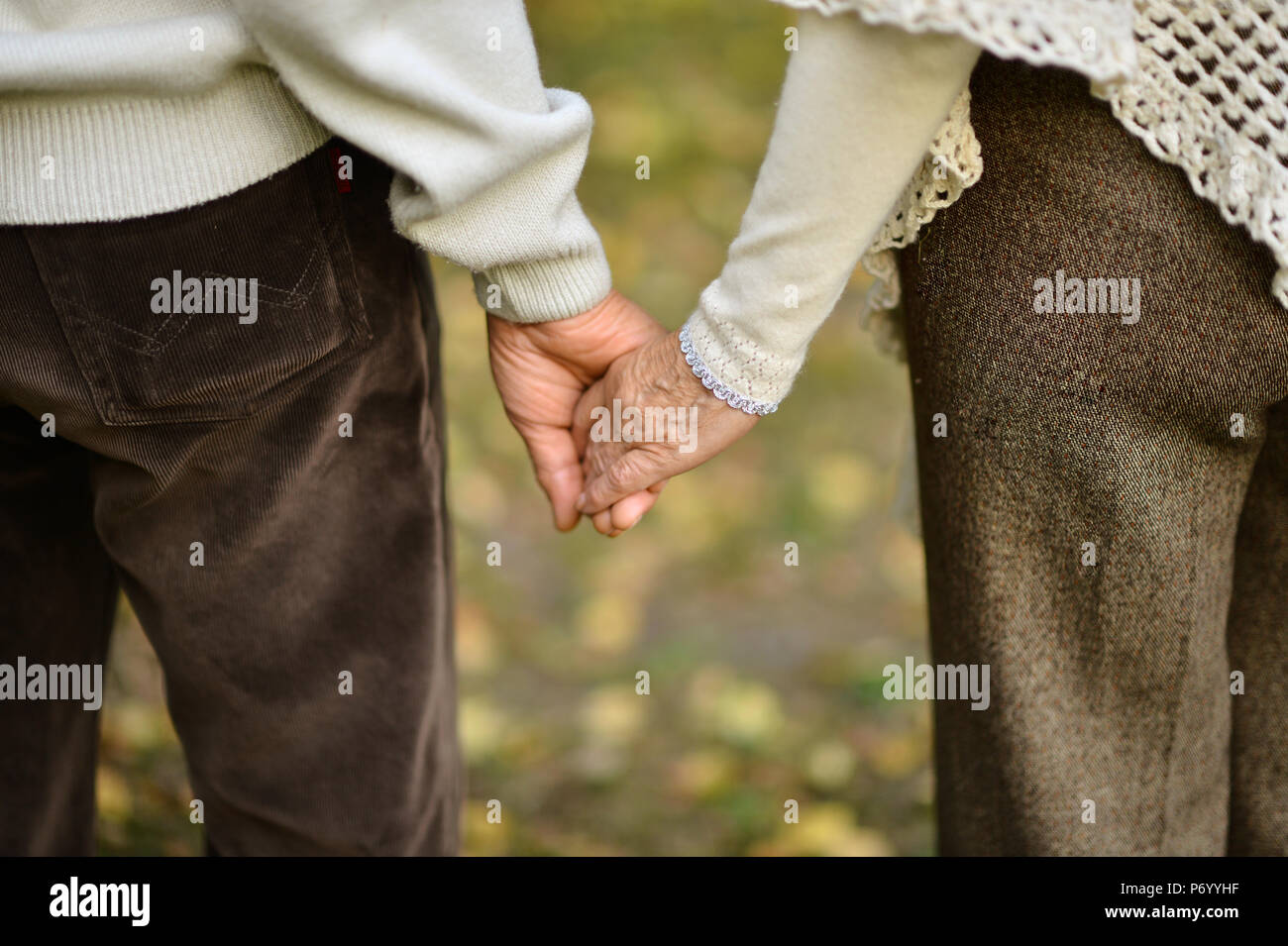 Elderly couple holding hands together Stock Photo - Alamy