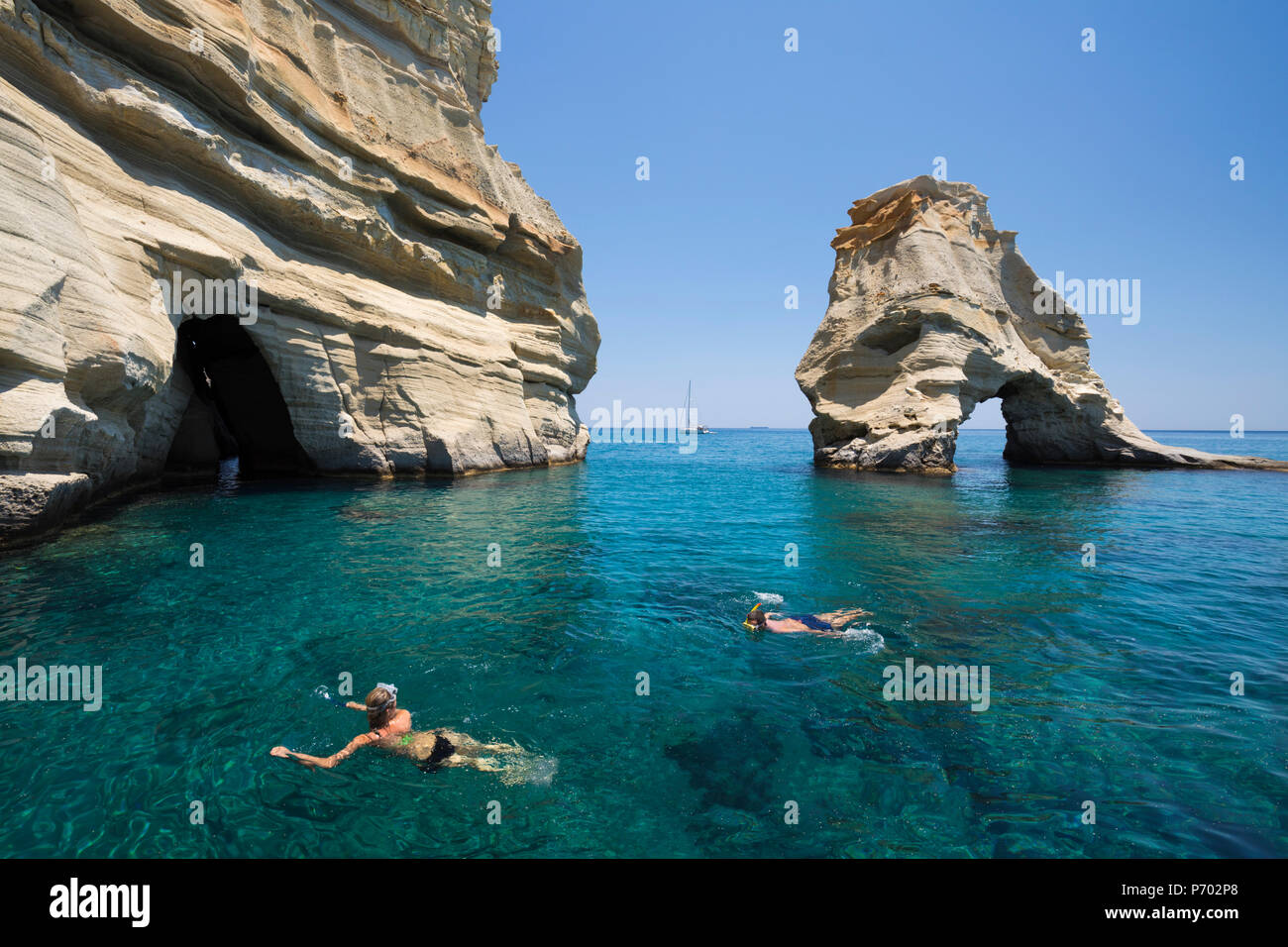 Snorkellers amongst rock formations with crystal clear water, Kleftiko ...
