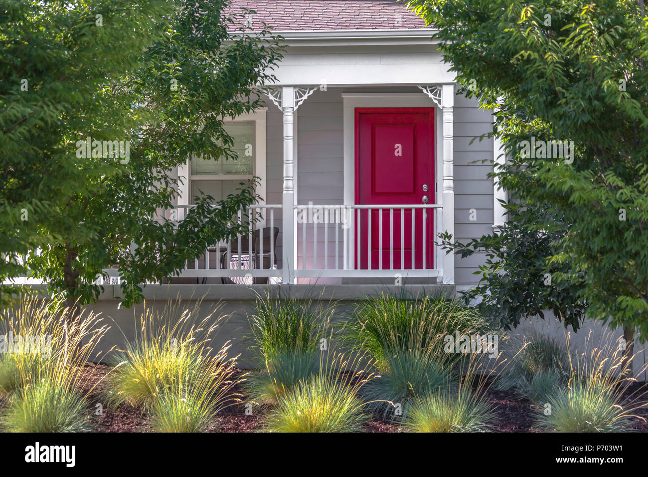 Red front door with front yard landscaping Stock Photo - Alamy