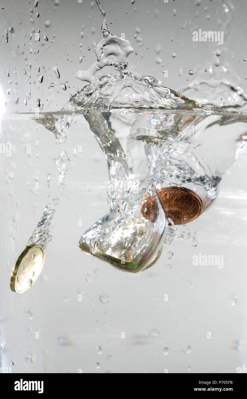 coins falling into the water still life Stock Photo - Alamy