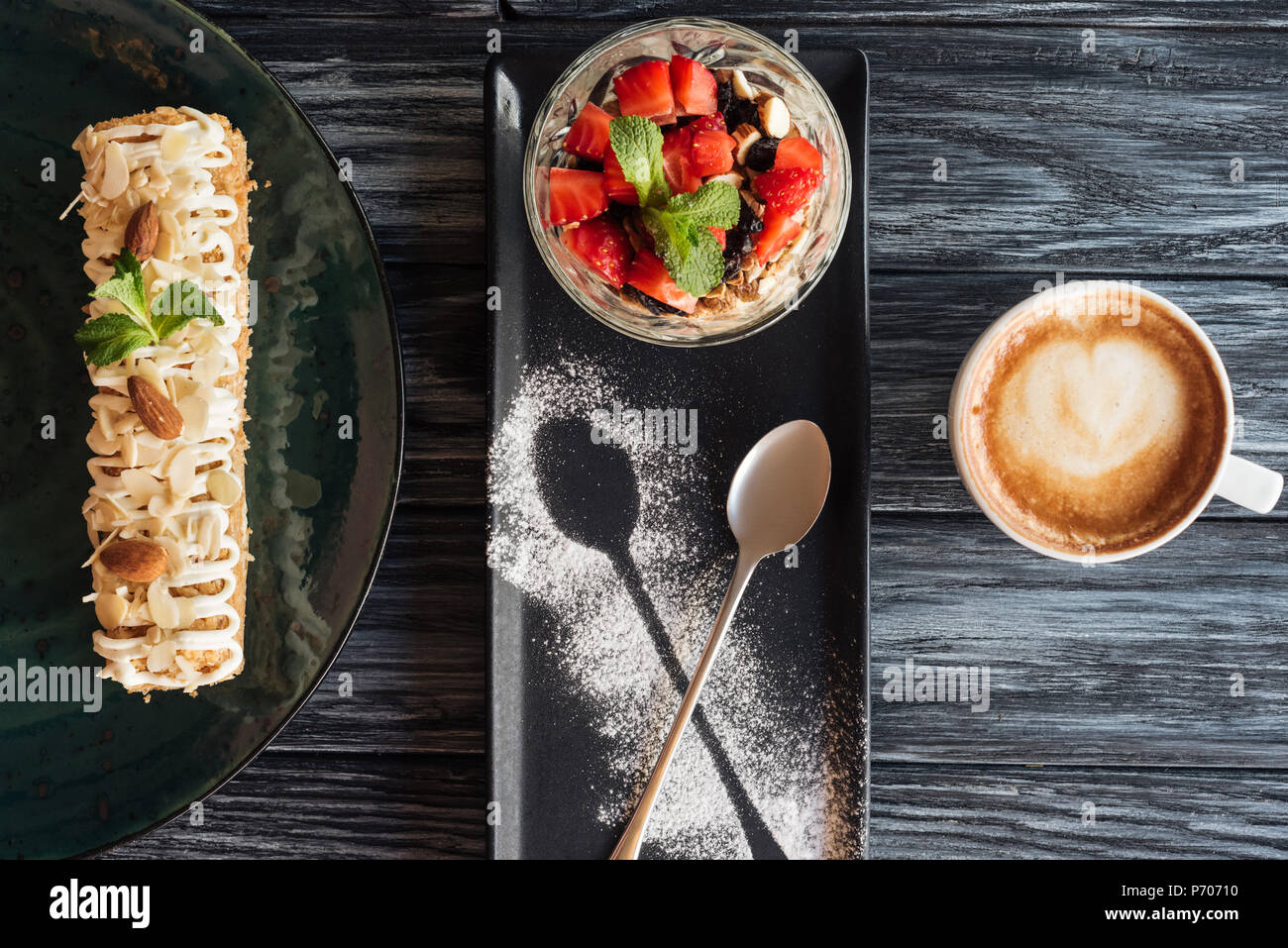 top view of sweet gourmet desserts and cup of coffee on wooden table ...