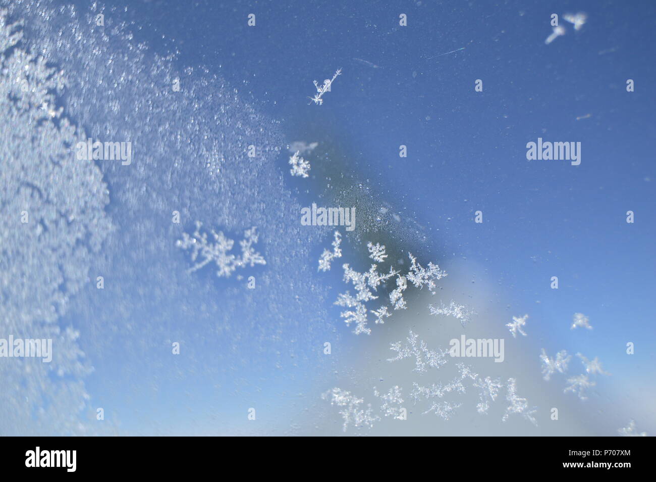 Snowflakes on the window of the plane. In the background, through the ...