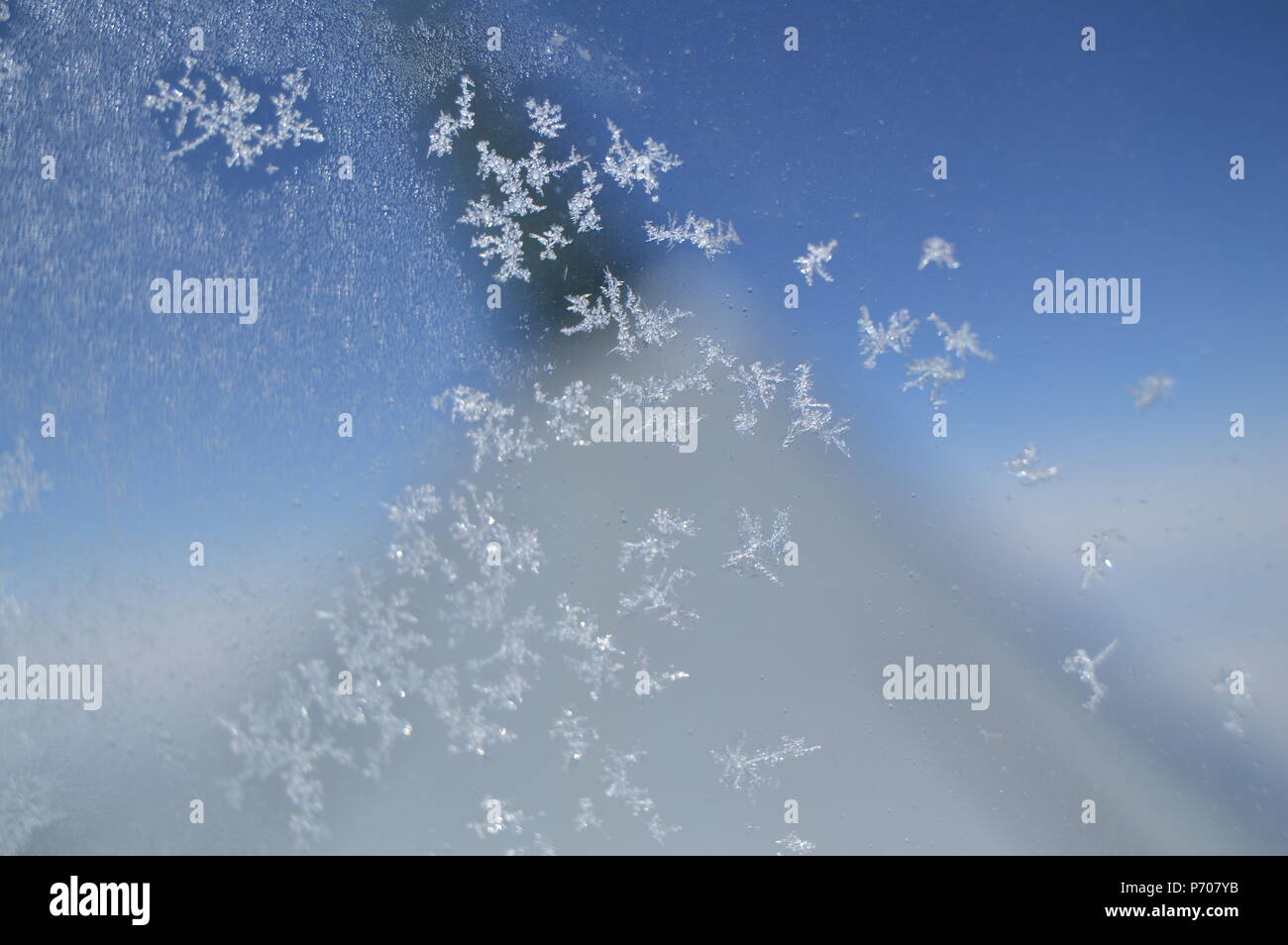Snowflakes on the window of the plane. In the background, through the ...