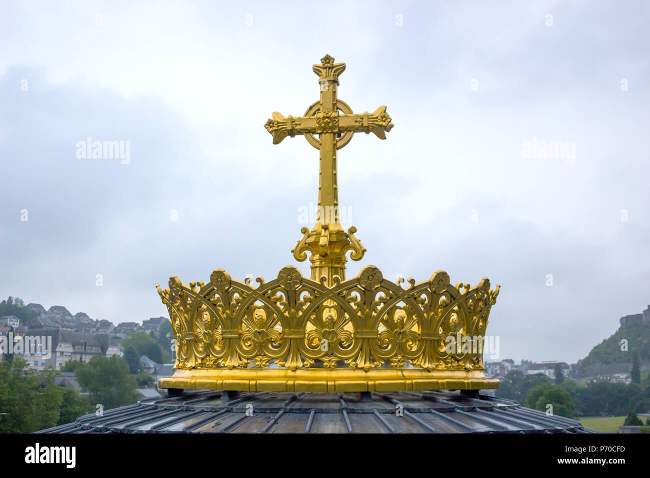 Golden cross and crown in lourdes france with dark sky Stock Photo - Alamy