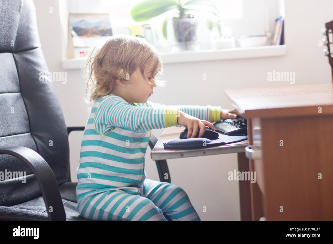 Childhood and technology ,Two years child using computer at home Stock ...