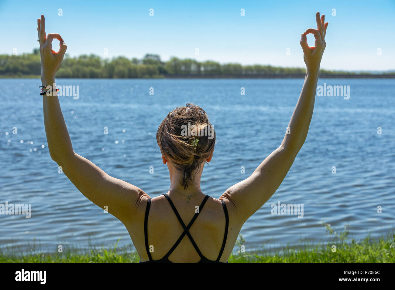 A yoga instructor demonstrates yoga poses during an outdoor yoga ...