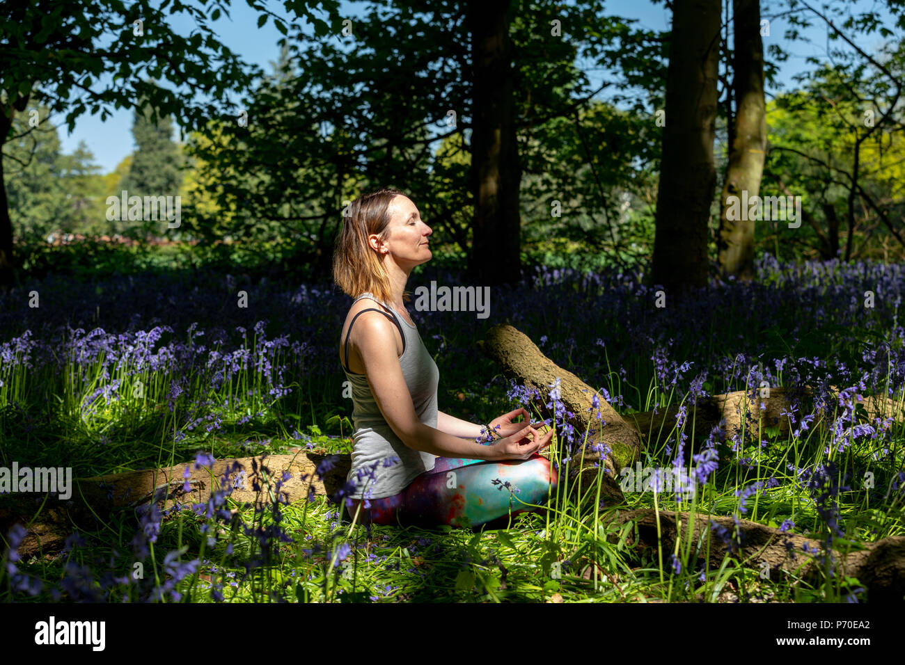 A yoga instructor demonstrates yoga poses during an outdoor yoga ...