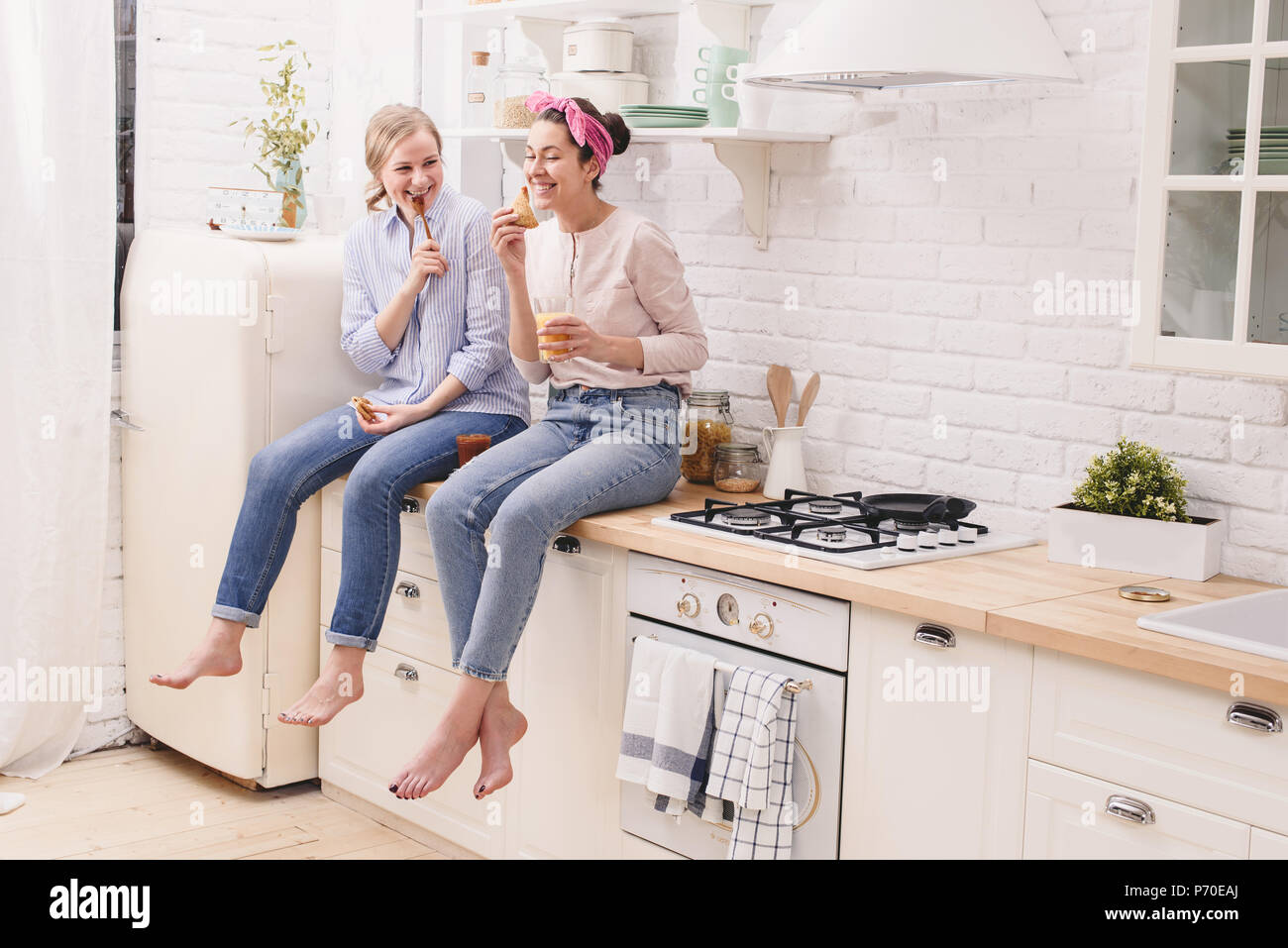 Cheerful women preparing breakfast together in the kitchen Stock Photo ...