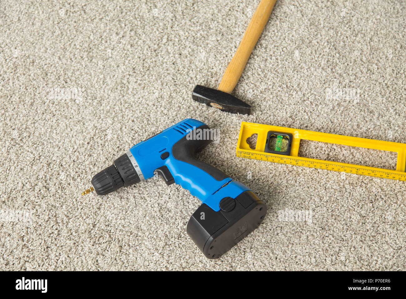 Construction concept - Hammer, drill and builders level on the floor ...