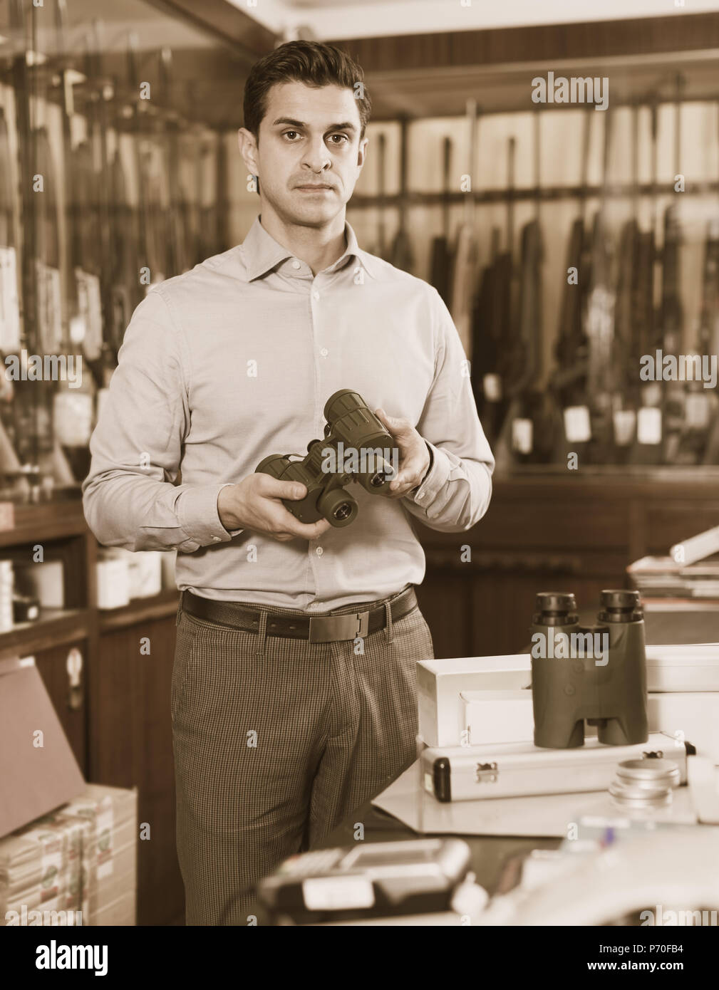 Confident male owner of hunting shop recommending ammunition and ...