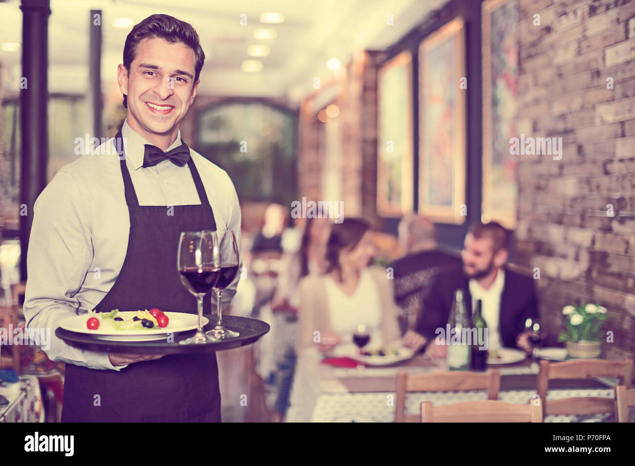 Portrait of smiling waiter with serving tray at restaurant Stock Photo ...