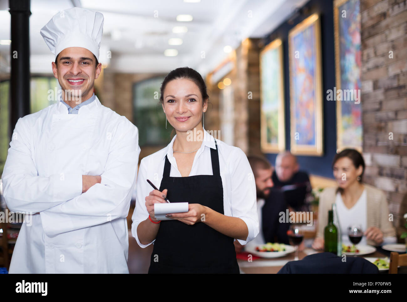 Portrait of smiling waitress with professional chef at restaurant ...