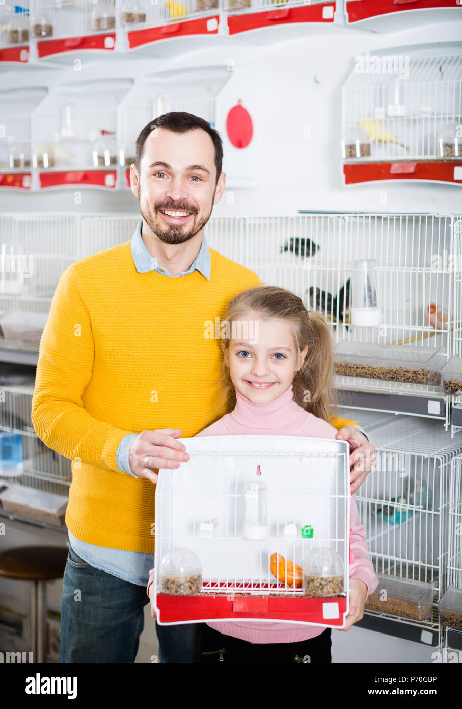 Smiling father and daughter show round bought a canary and cage bird in ...