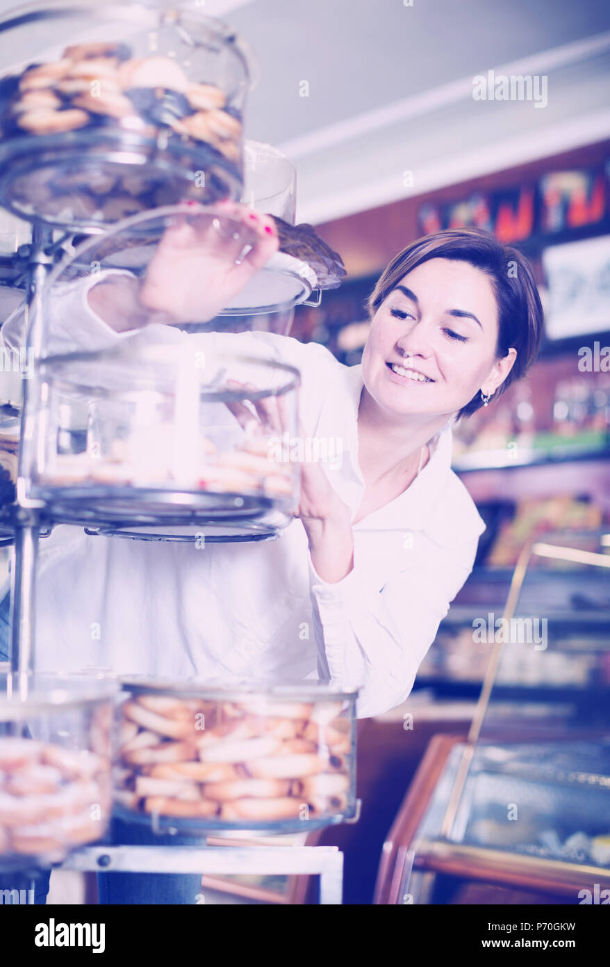 Young female customer examining desserts in confectionery Stock Photo ...