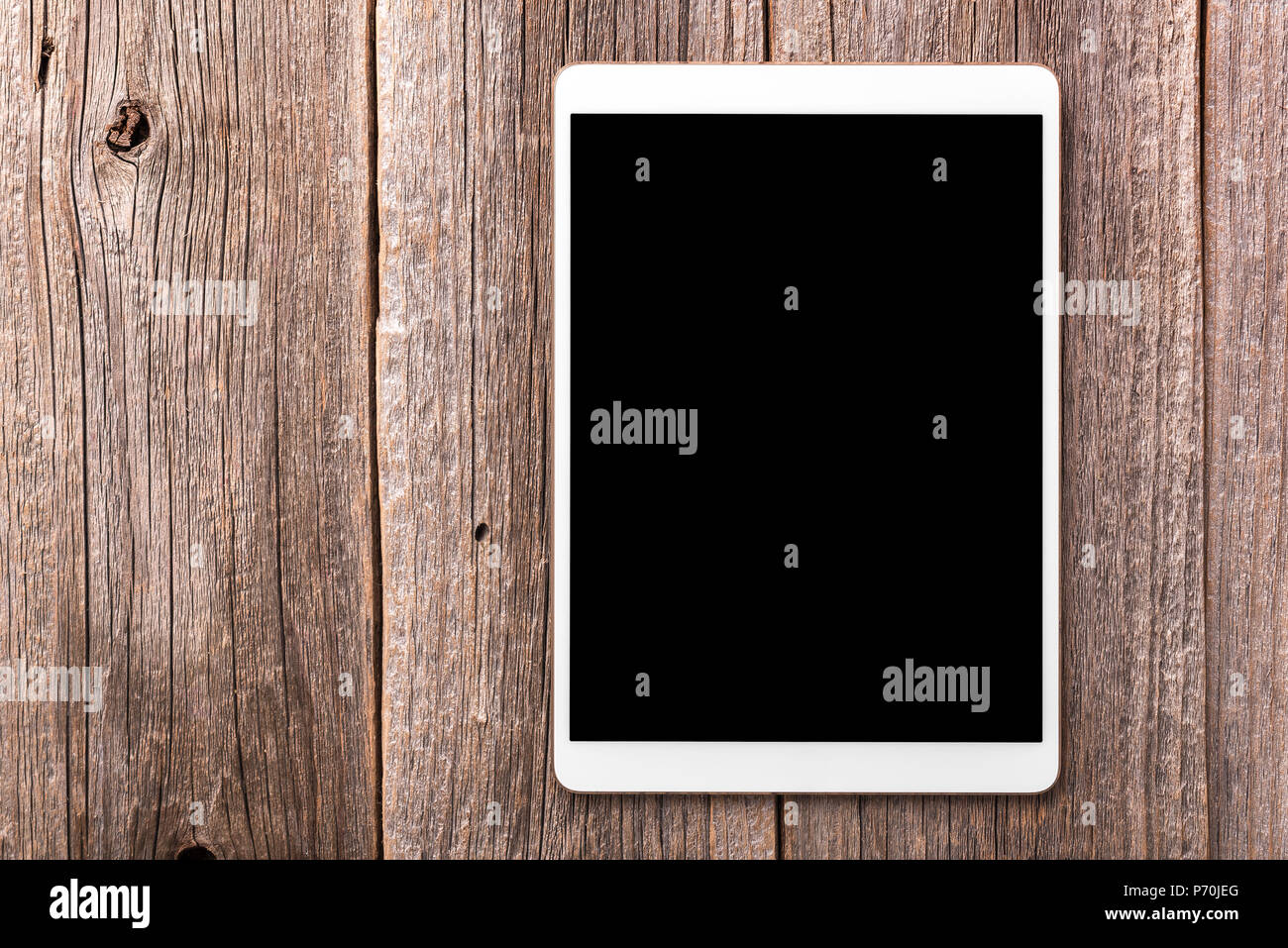White tablet pc on old wood table background Stock Photo - Alamy