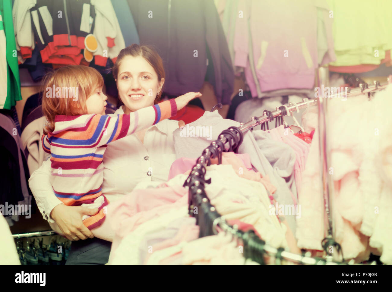 Happy family chooses wear at clothes shop Stock Photo - Alamy