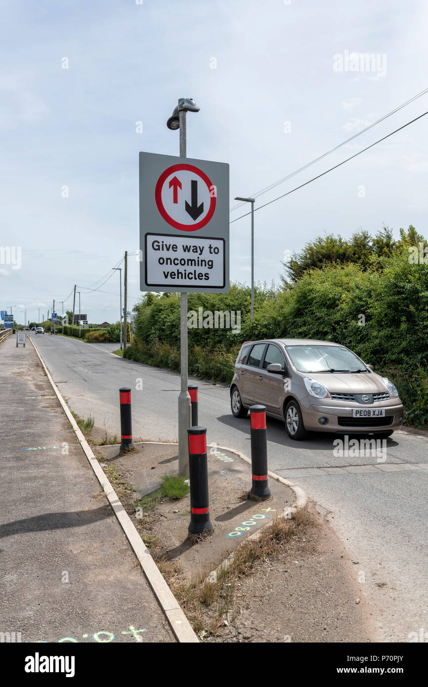 Car passing a "Give way to oncoming vehicles" sign in Blackpool ...