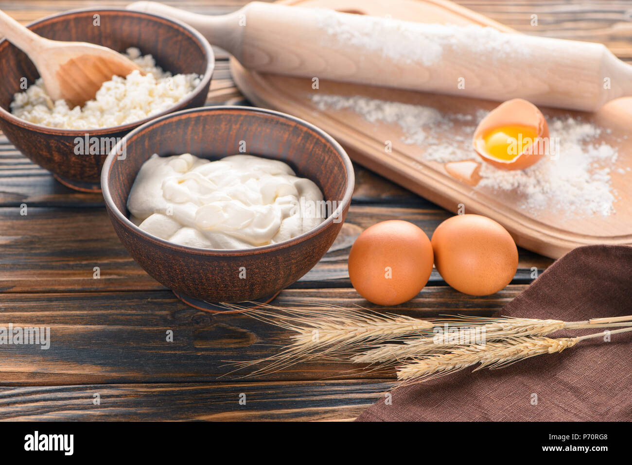 close-up view of cottage cheese, wheat ears, sour cream, eggs and flour ...