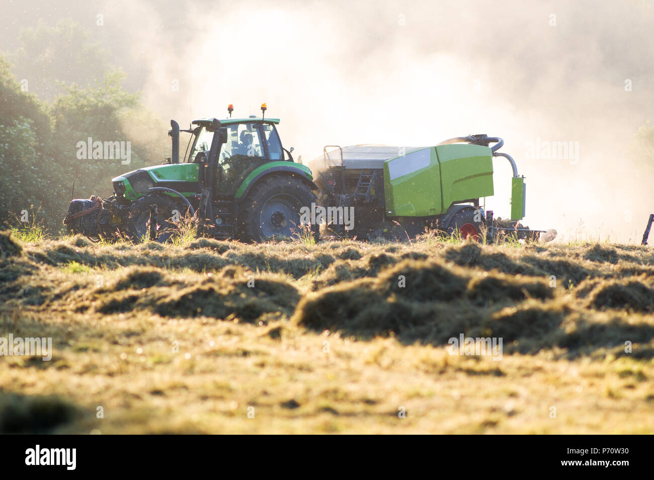 Farmer with tractor in field, making hay Stock Photo - Alamy