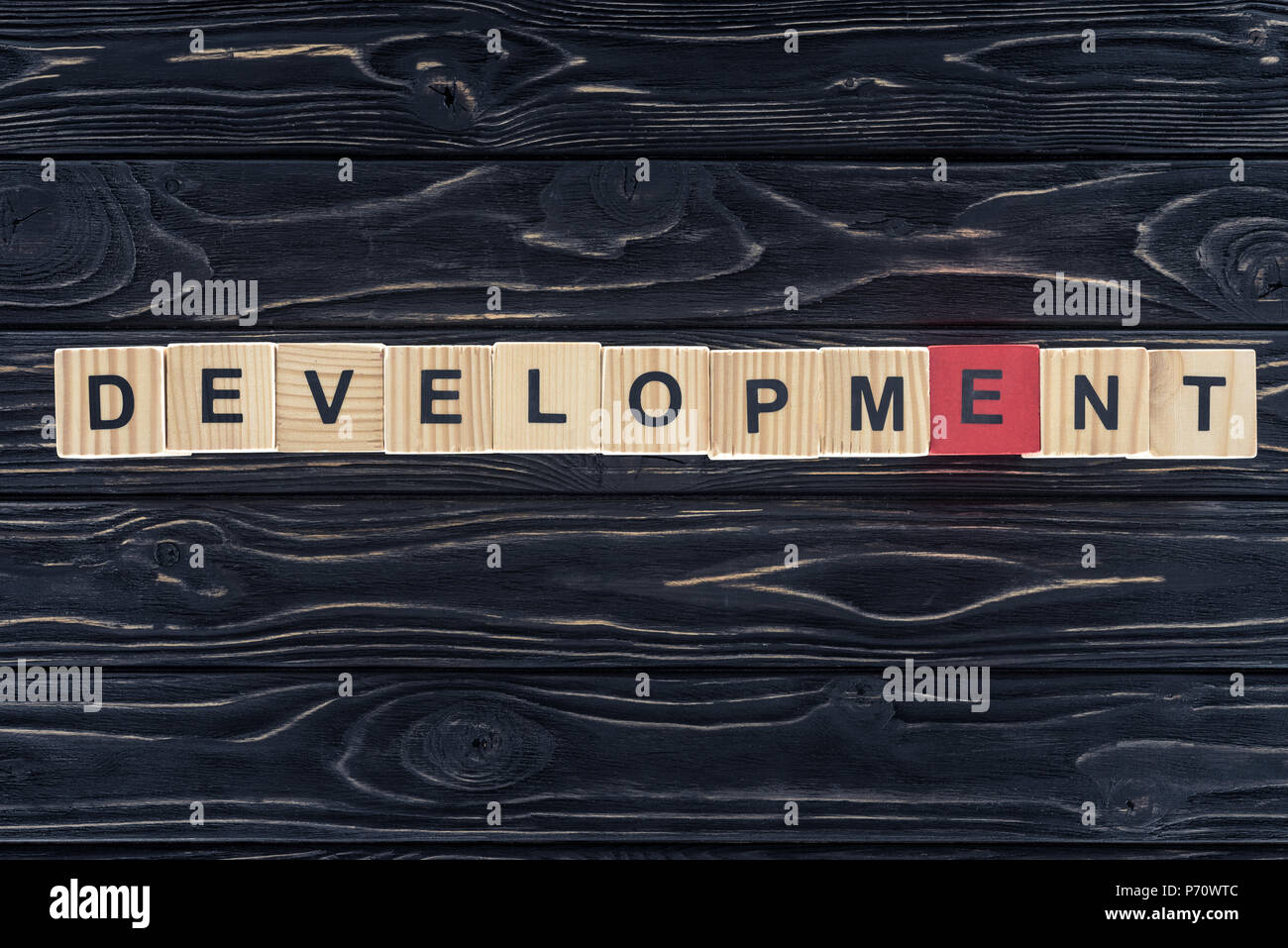 top view of word development made of wooden blocks on dark wooden ...