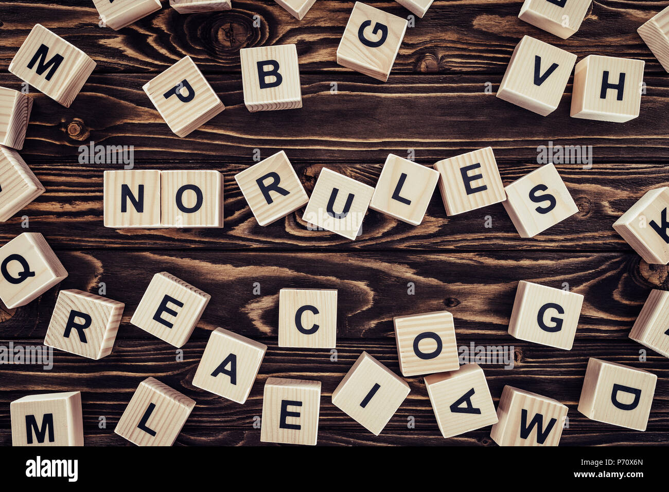 top view of no rules lettering made of wooden cubes on brown wooden ...