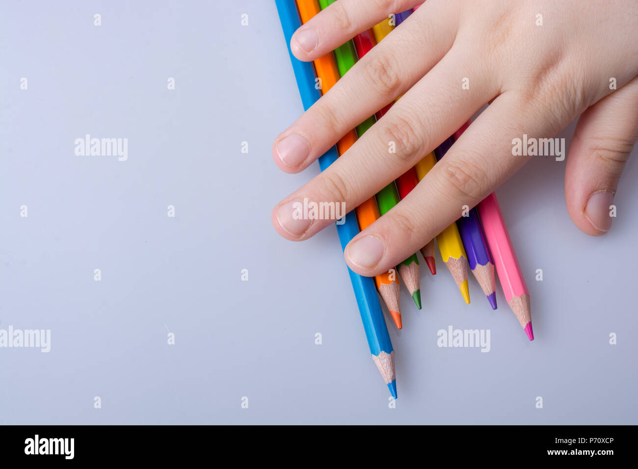 Hand holding color Pencils placed on a white background Stock Photo - Alamy