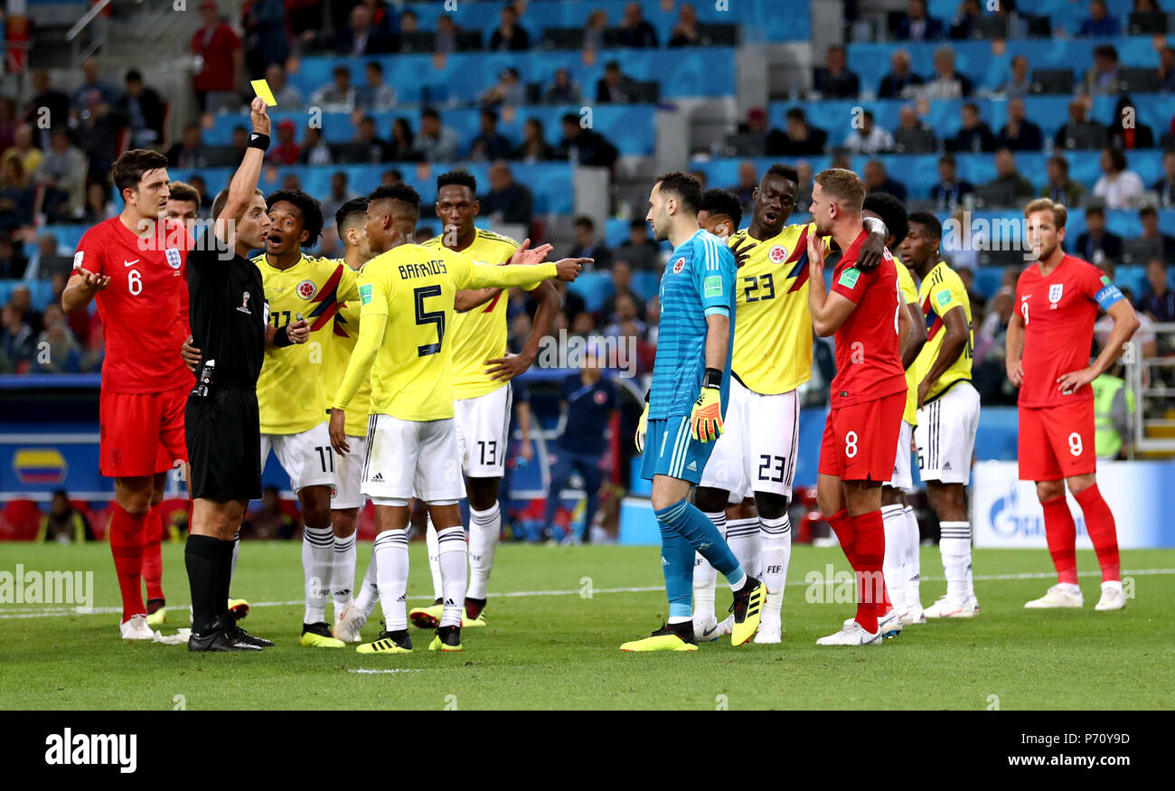 Referee Mark Geiger shows a yellow card to Colombia's Wilmar Barrios ...
