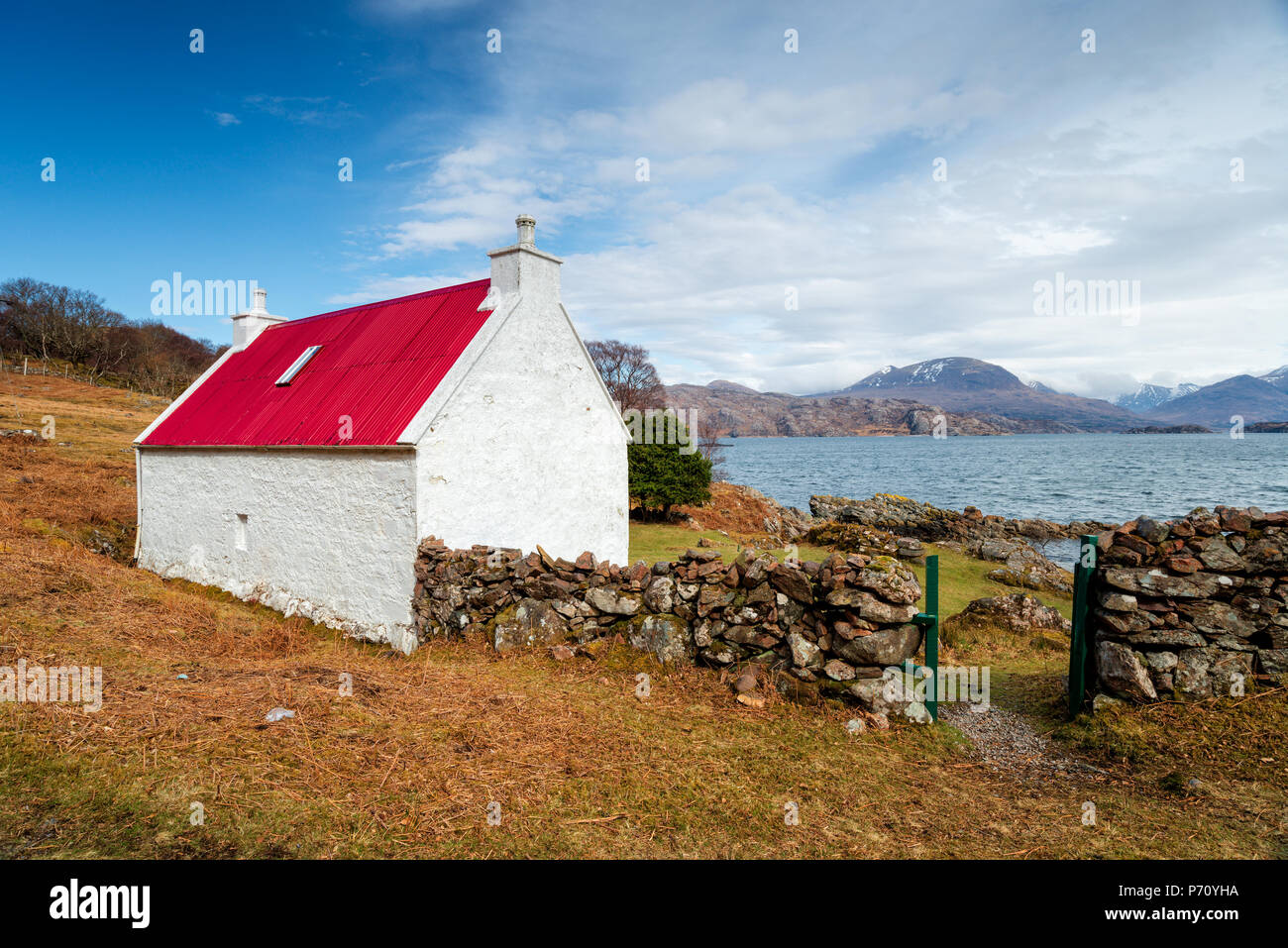 A pretty cottage with a red roof on the shores of Loch Shieldaig in ...