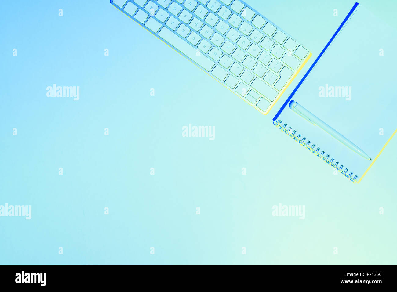 blue toned picture of empty textbook, pencil and computer keyboard ...