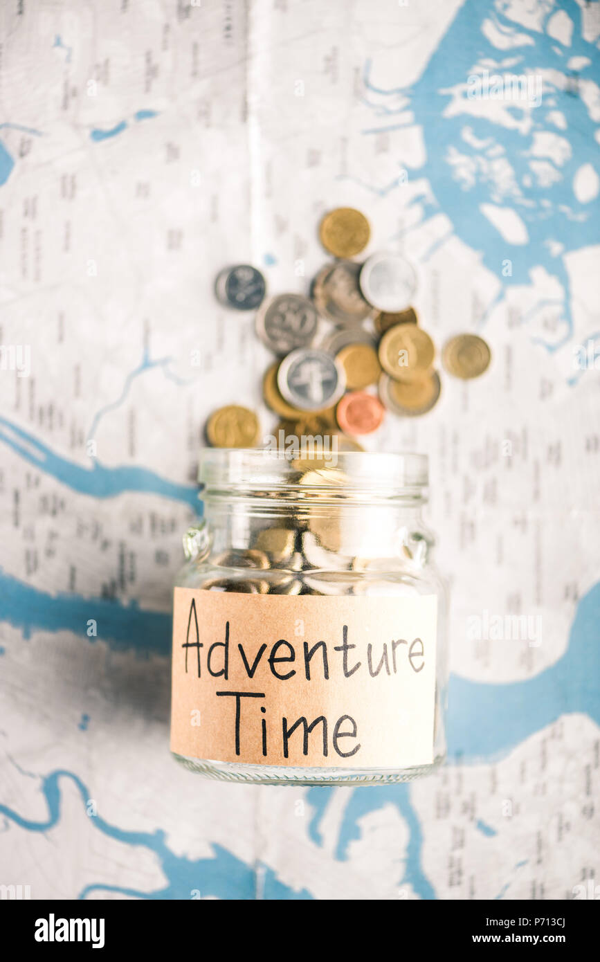 top view of coins spilled from jar with adventure time sticker on map ...