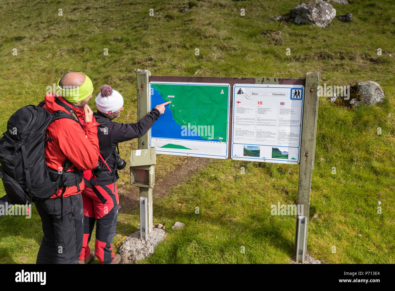 Hikers looking at maps, Gasadalur, Vagar Island, Faroe Islands, Denmark ...