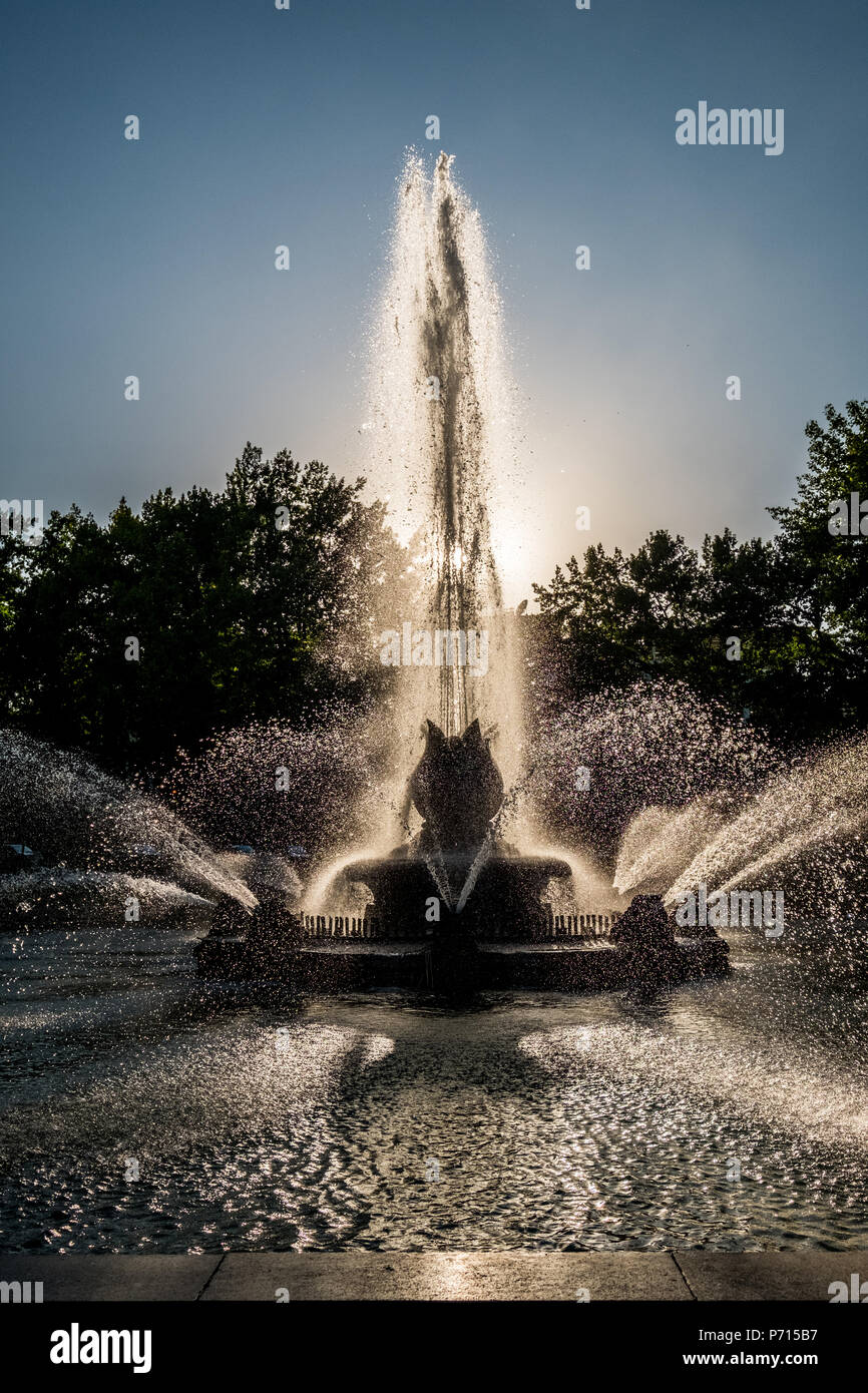 Sun setting behind water feature Stock Photo - Alamy