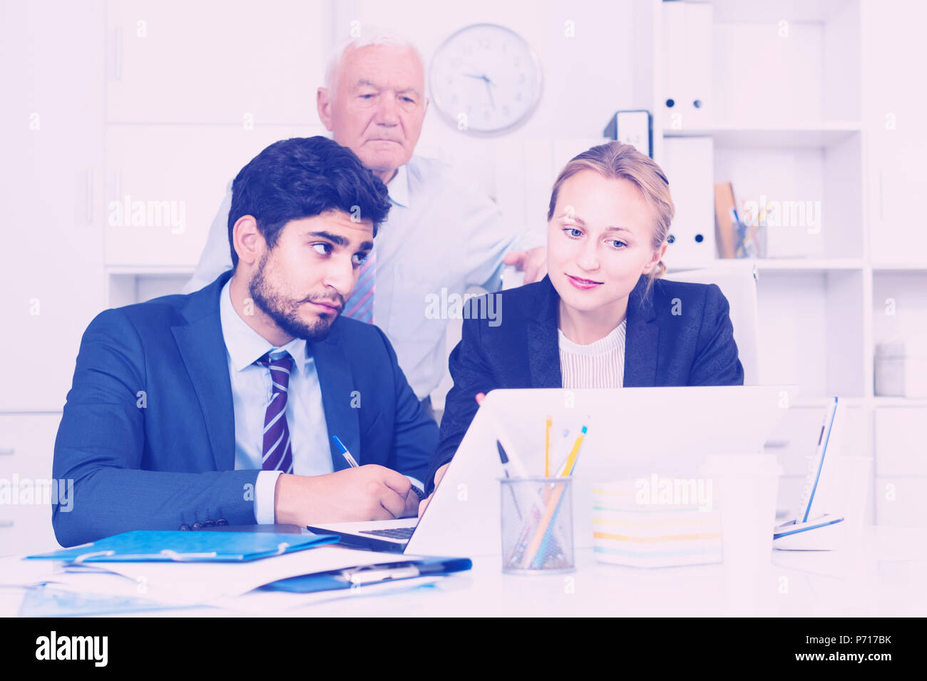 Employees are demonstrating reports on laptop to mature boss in the ...