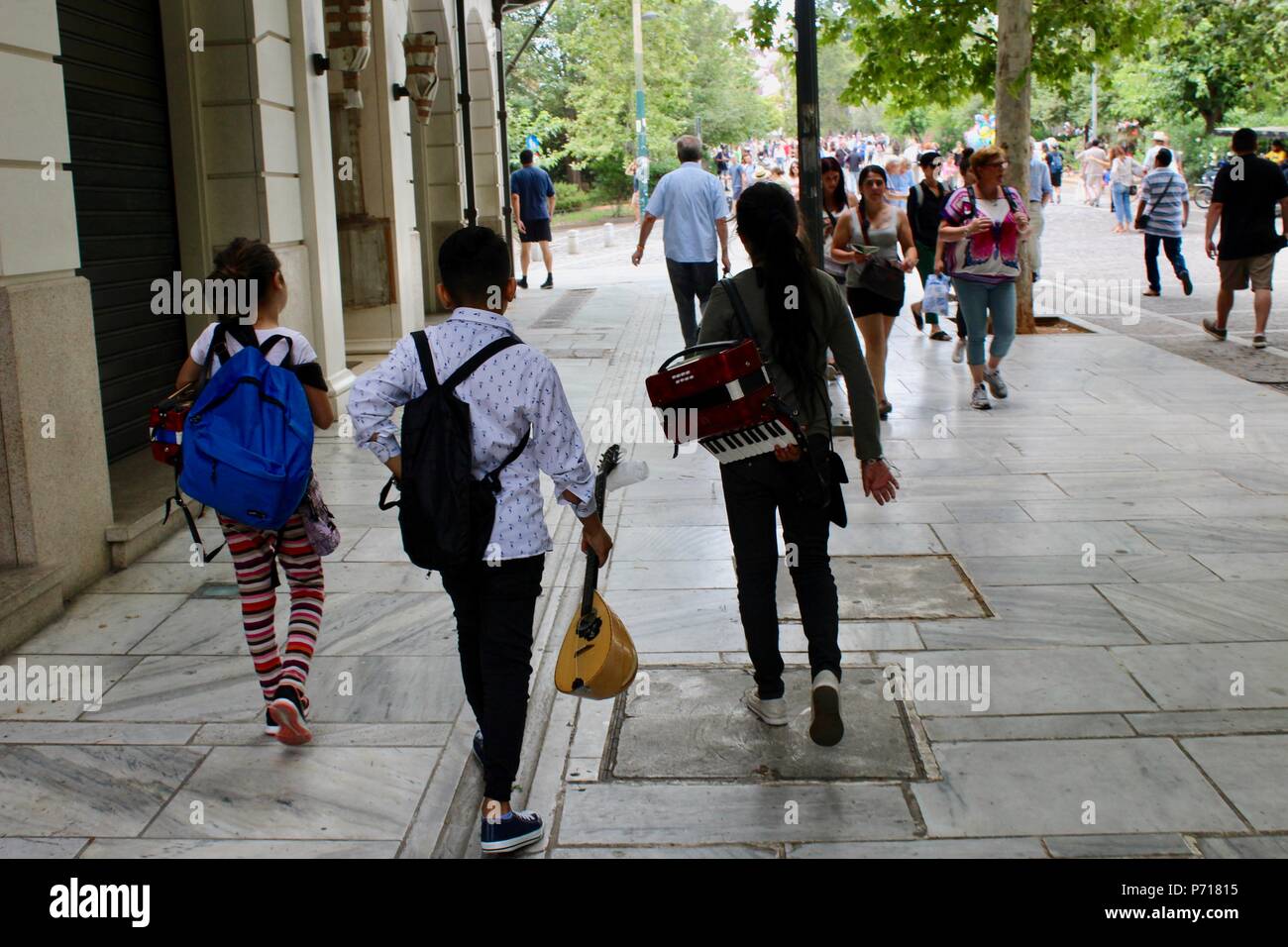 a group of roma gypsy children with musical instruments walking through ...