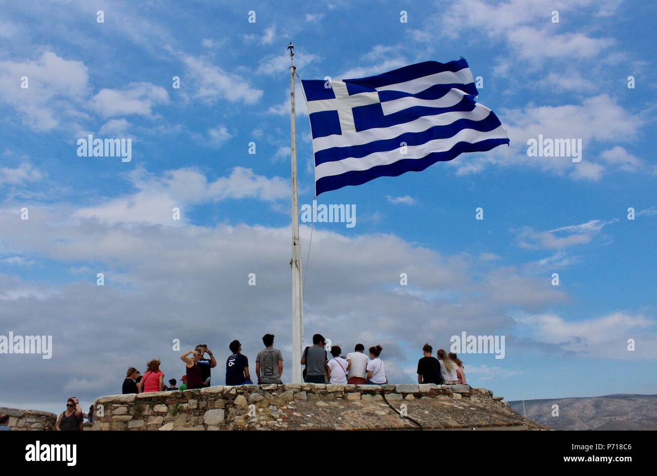 he greek flag flying on a sunny day in athens greece over the acropolis ...