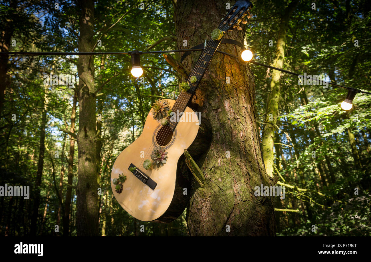 Guitar in a woods in trees at a festival, with hippy overtones Stock ...