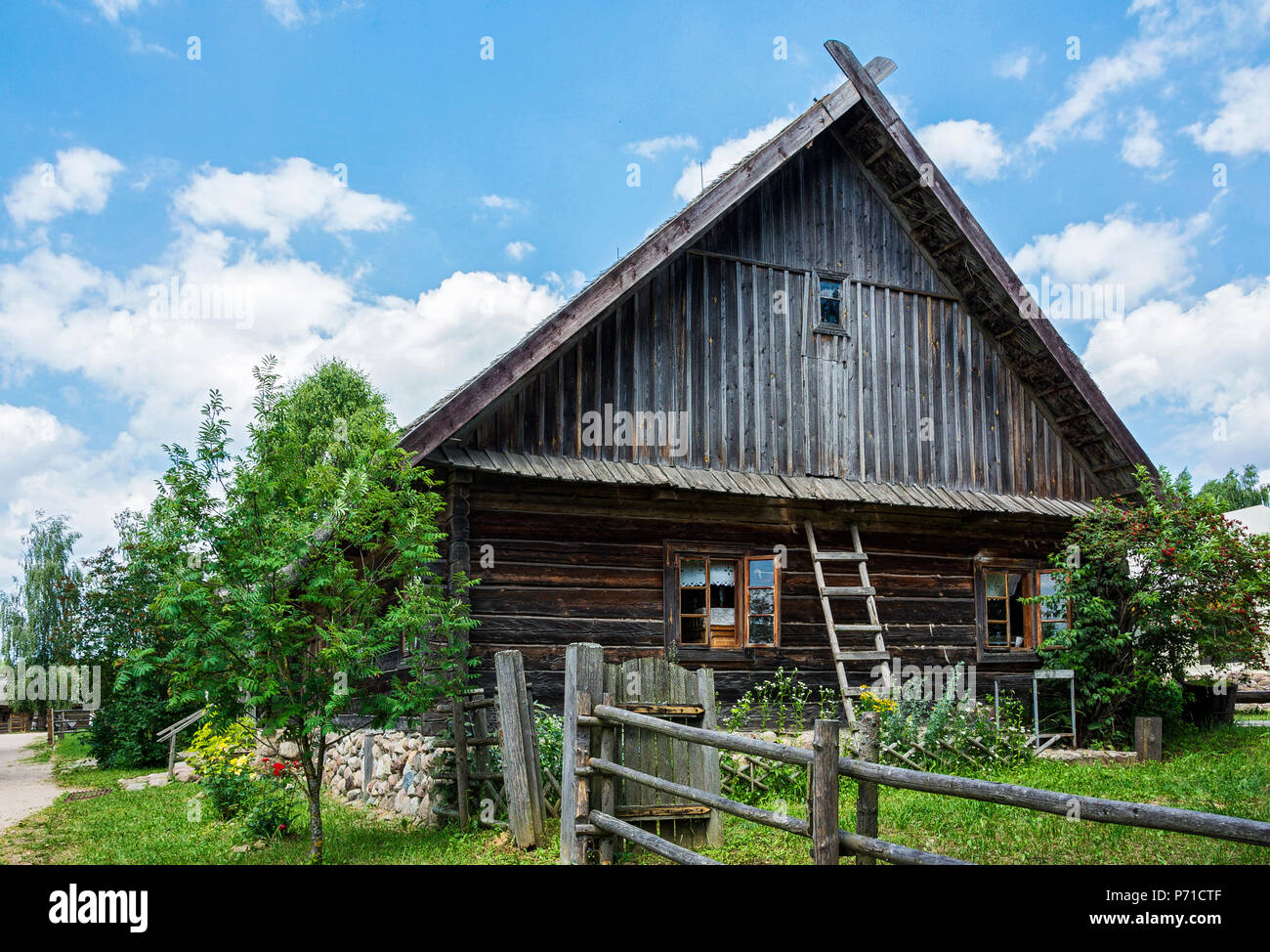 Rural architecture. Old village log hut and the yard behind the fence ...