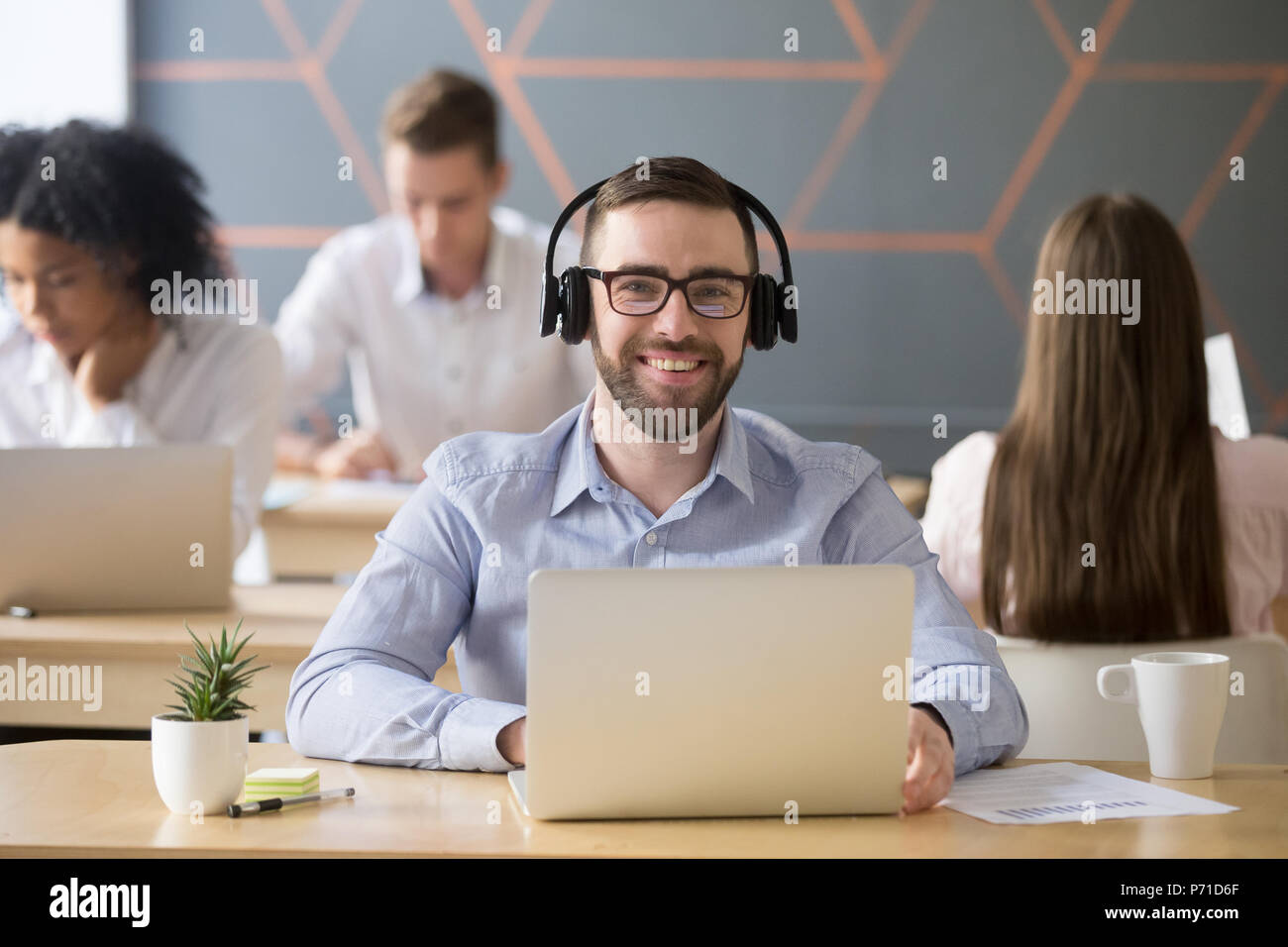 Portrait of smiling male employee in headset posing for picture Stock ...