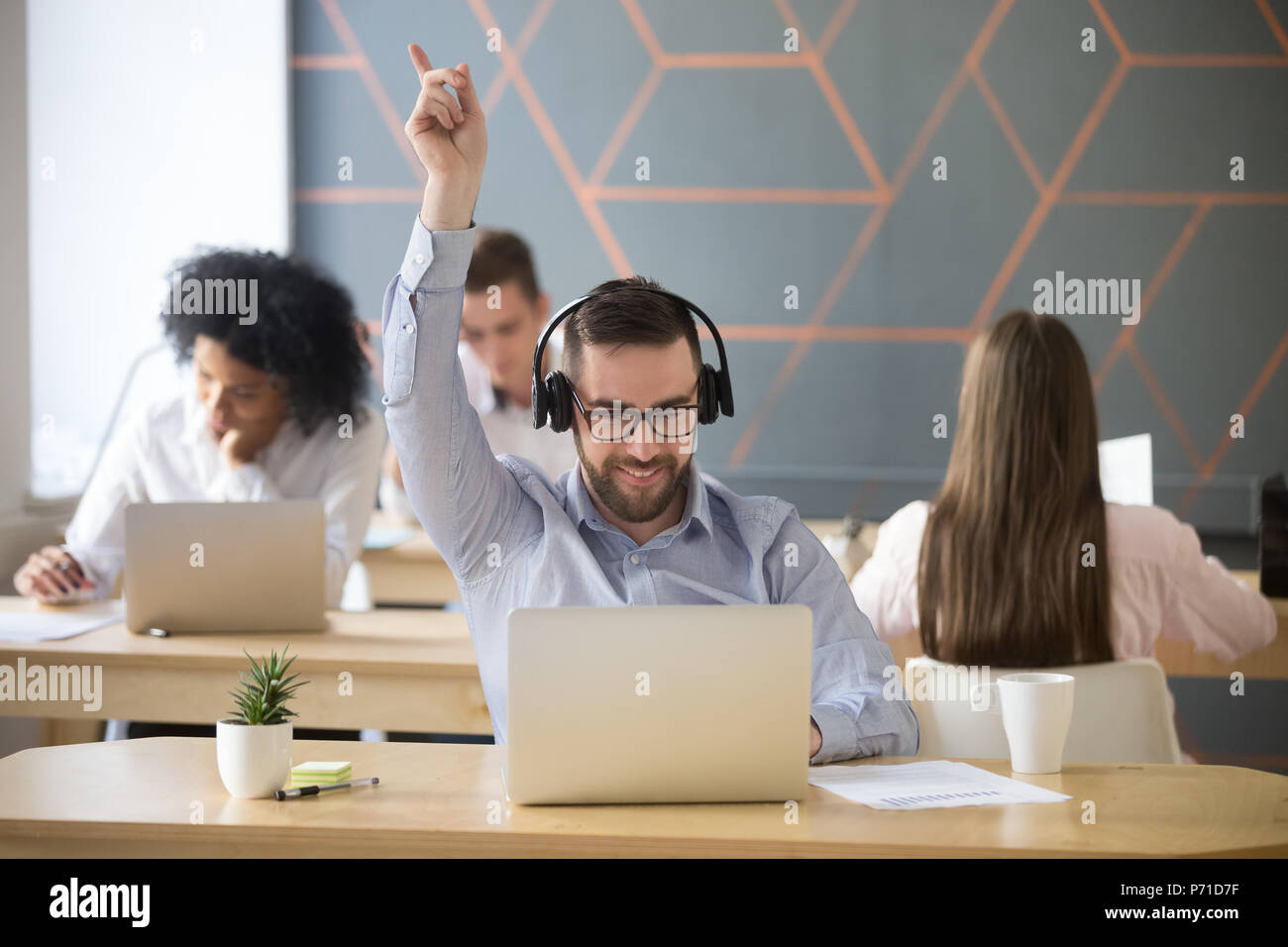 Happy male worker enjoying music in headset in office Stock Photo - Alamy