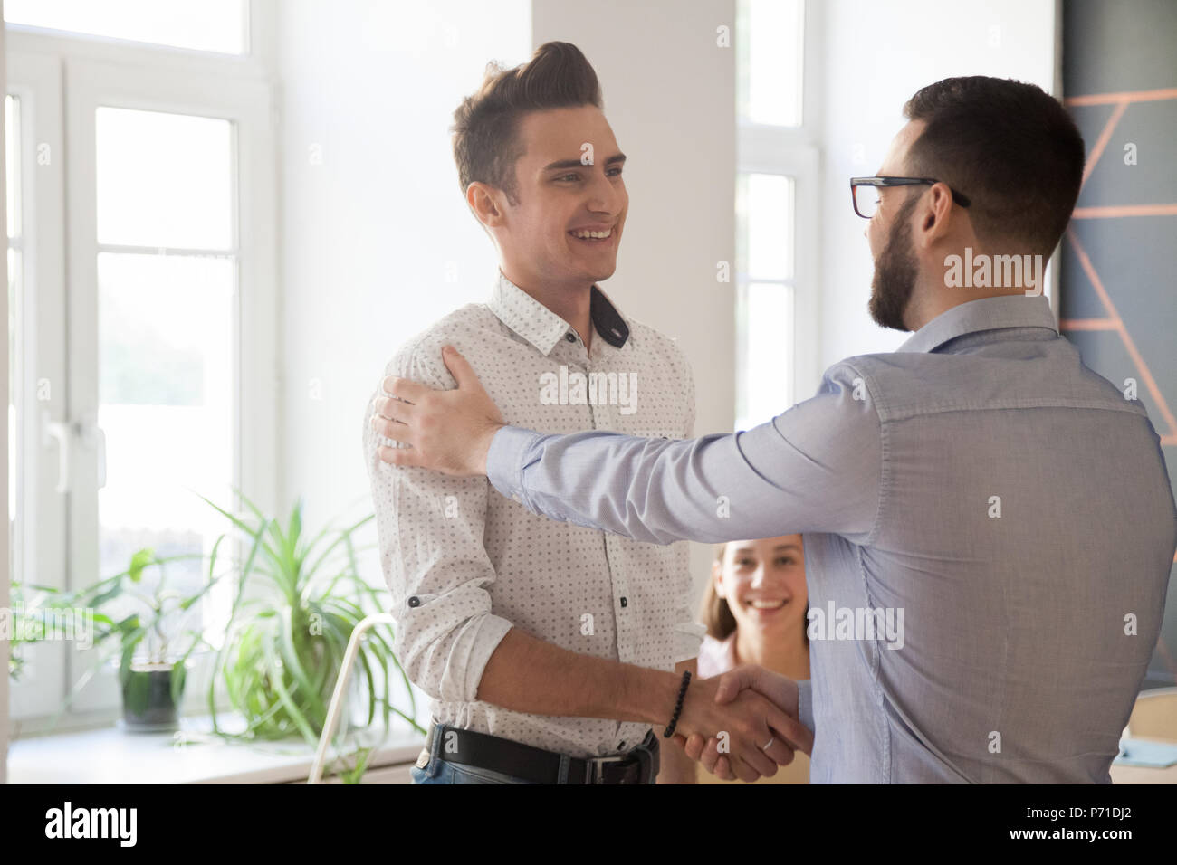 Male boss handshaking intern greeting with job promotion Stock Photo ...