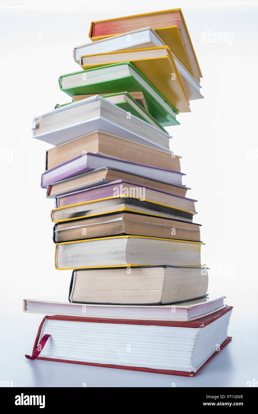 pile of colored different books on white table Stock Photo - Alamy