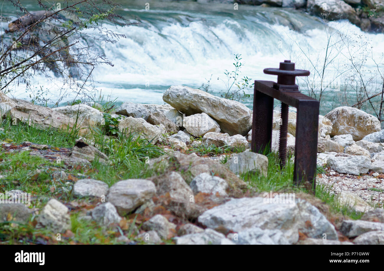 Iron pillar for anchoring boats near a small waterfall in the forest ...