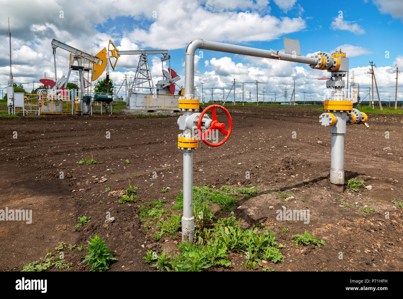 Pipeline with control valve against the background pump jack fracking ...
