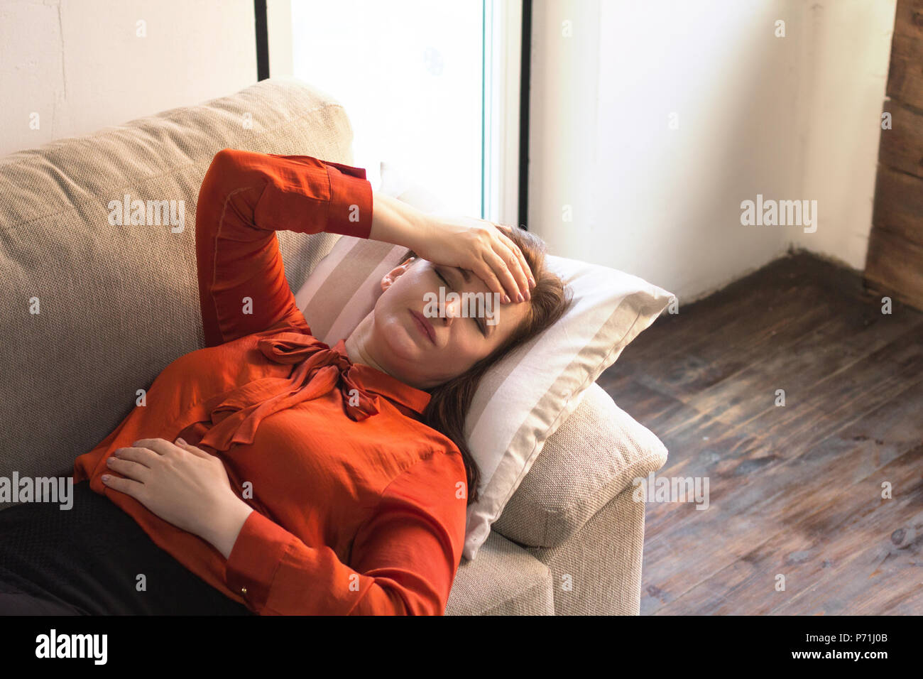 Beautiful lady having rest on sofa Stock Photo - Alamy