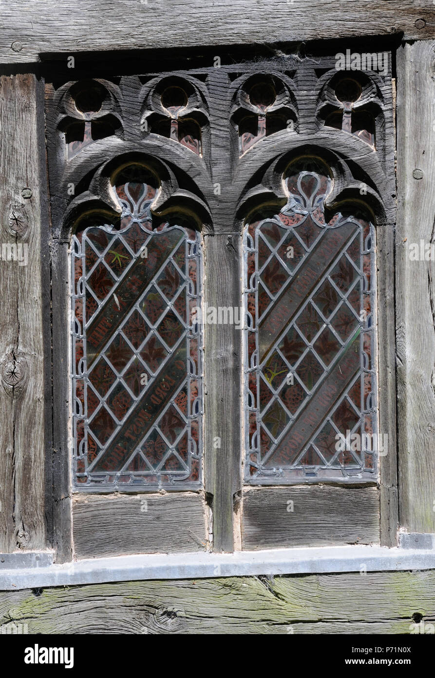 A weathered wooden window frame containing stained glass at the church ...