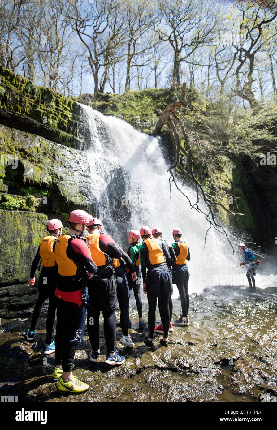 An instructor supervises a group gorge walking with Adventure Wales on ...
