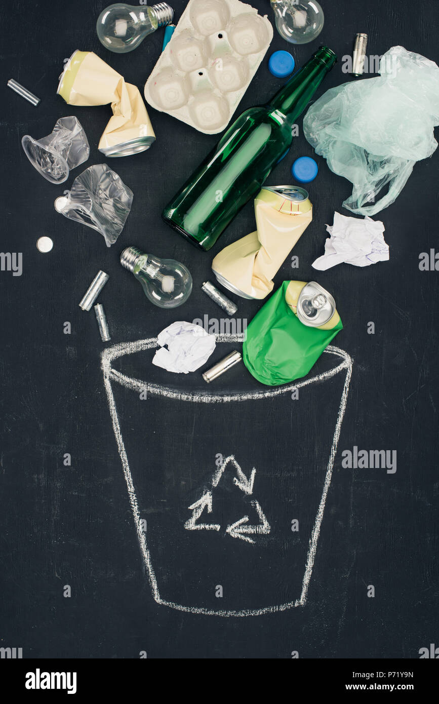 various types of trash falling into drawn trash can with recycle sign ...